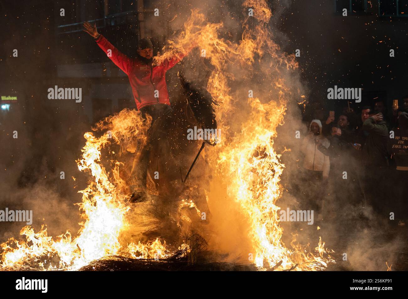 A horse rider jumps over a bonfire during "Las Luminarias" celebration ...