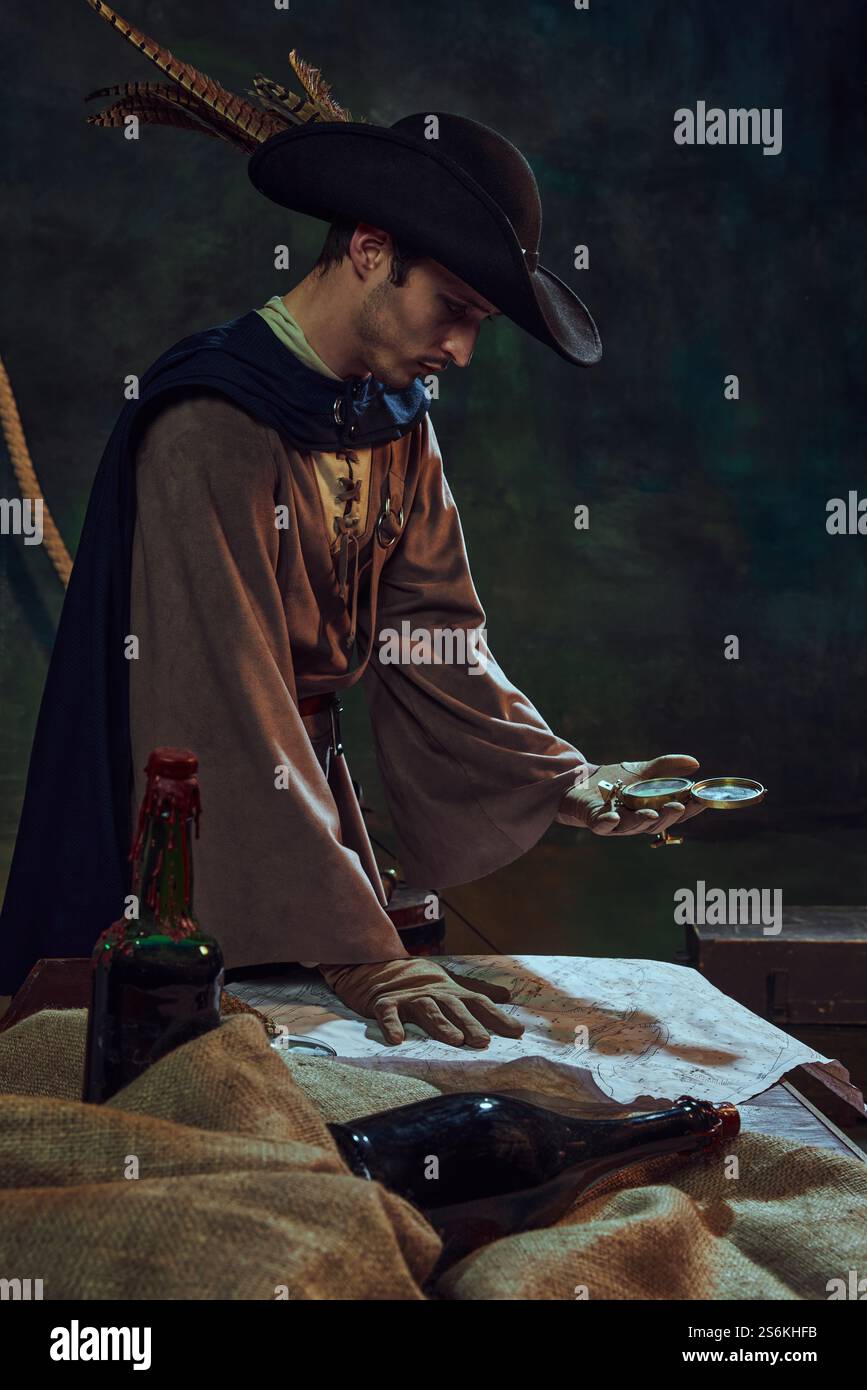 Focused man pirate captain in feathered hat and gloves, looking at ...