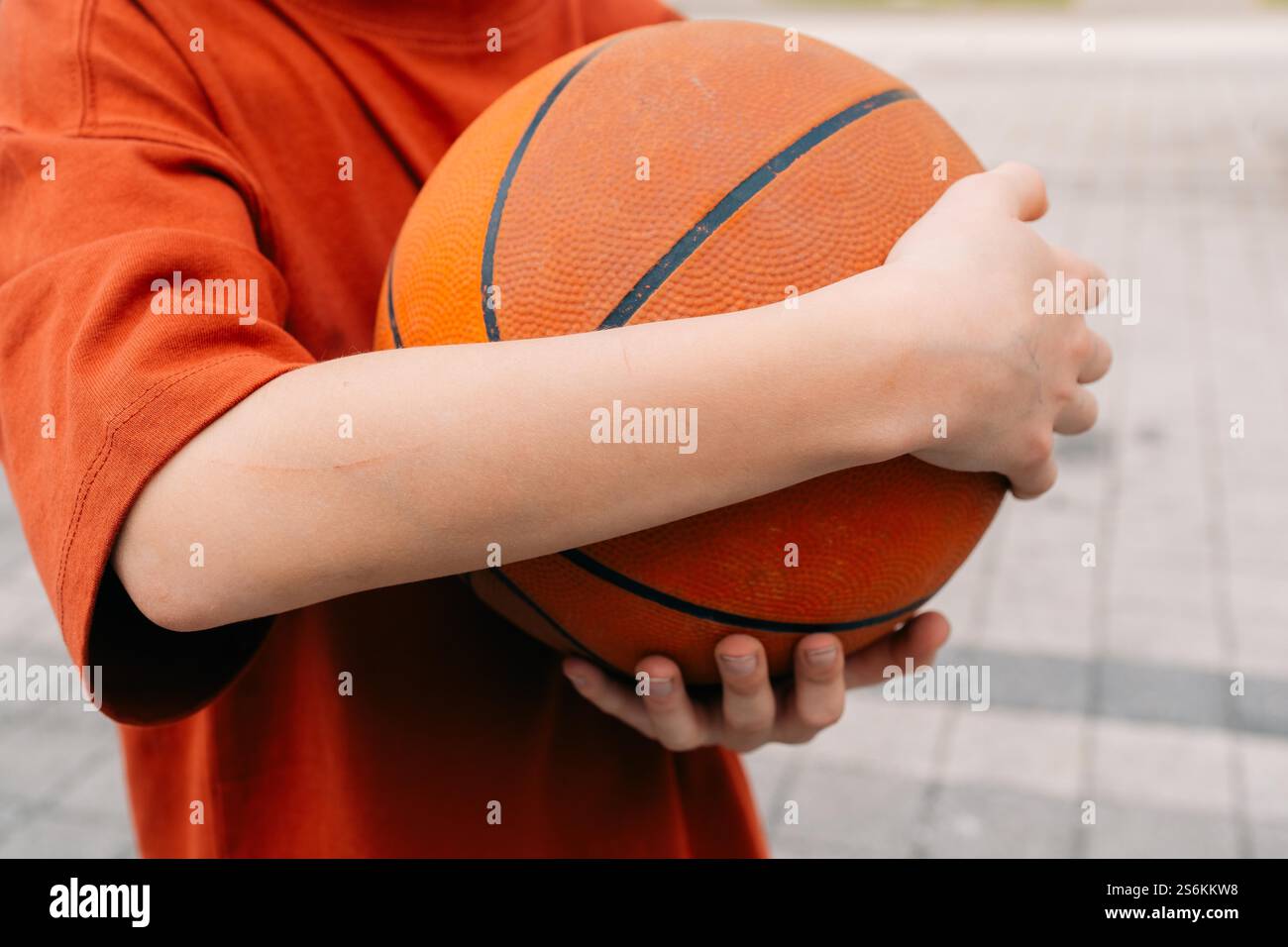 teenage boy wrapped his hands around the ball after playing basketball ...
