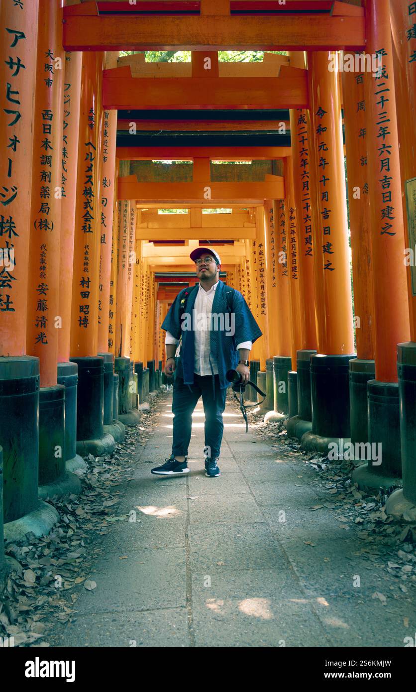 A stylish male traveler standing in the iconic pathway of vibrant ...