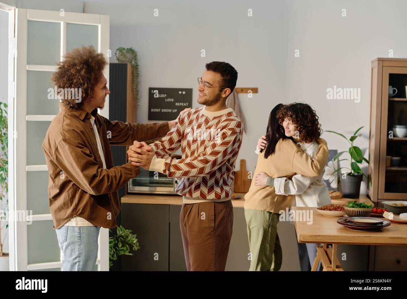 Wide shot of biracial old friends doing bro handshake while their ...