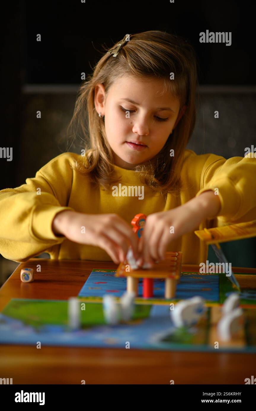 A girl plays board games at the table, enjoying the fun and challenge ...