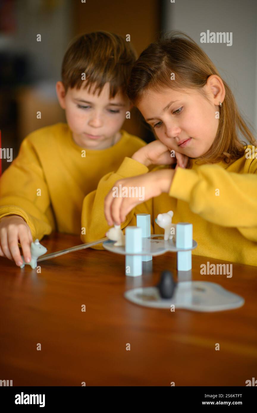 A boy and girl play board games at home, enjoying their time together ...