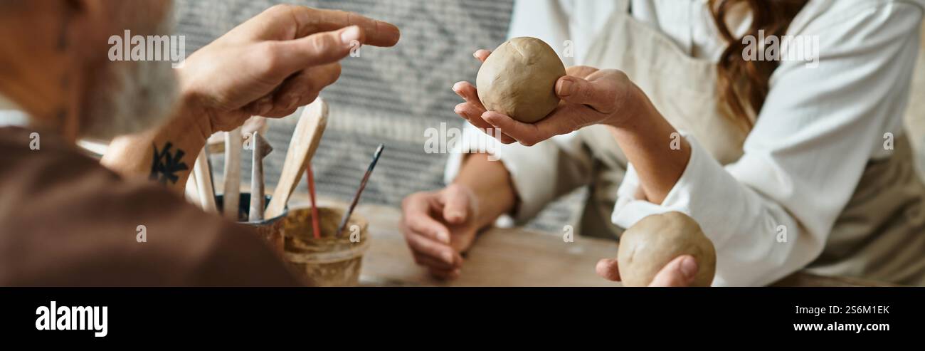 mature couple shares a pottery class, shaping clay and enjoying each ...