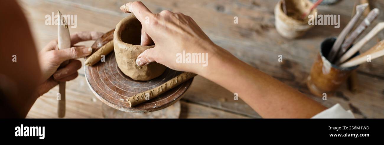 A mature woman spends quality time in a pottery class, shaping clay ...