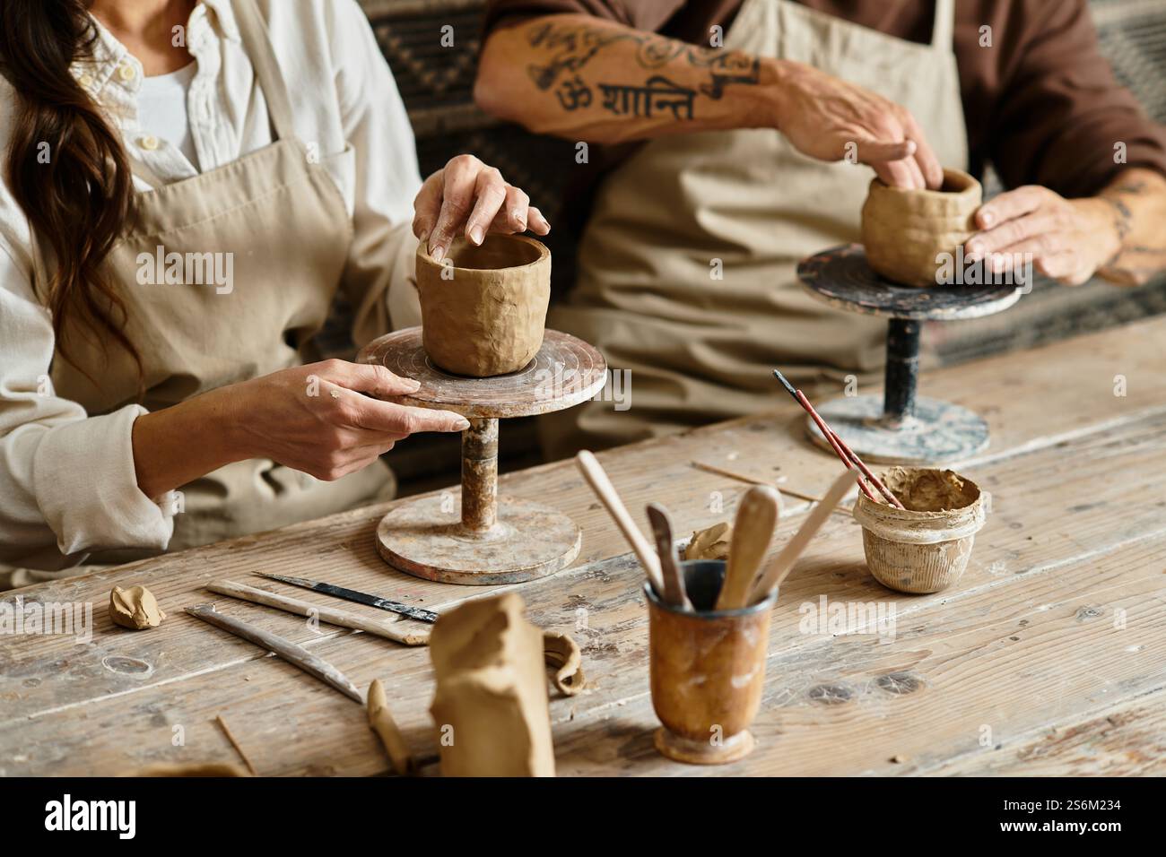 Mature couple enjoys a pottery class, shaping clay and sharing quality ...