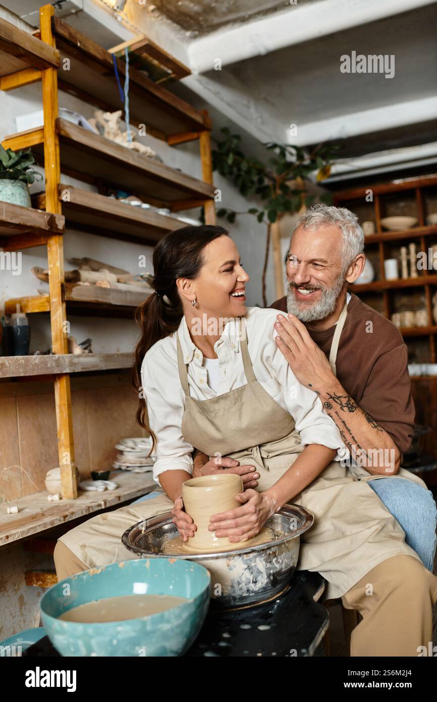 Mature couple in a pottery class joyfully shaping clay, sharing ...