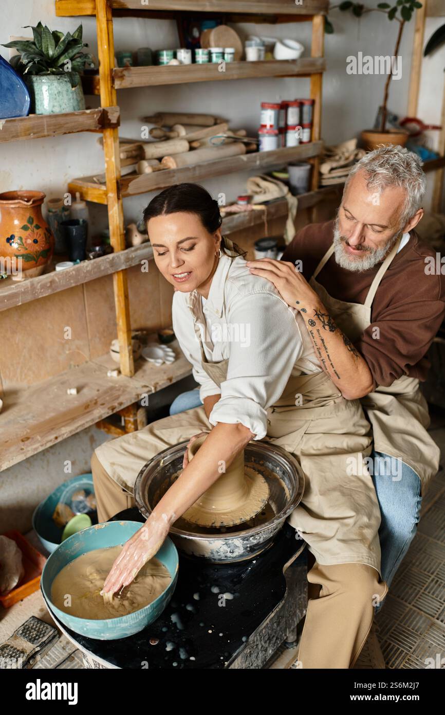 Mature couple joyfully shapes clay together, sharing quality time in a ...