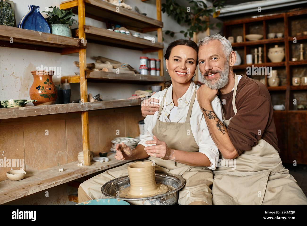 A couple joyfully shapes clay together in pottery class, savoring their ...