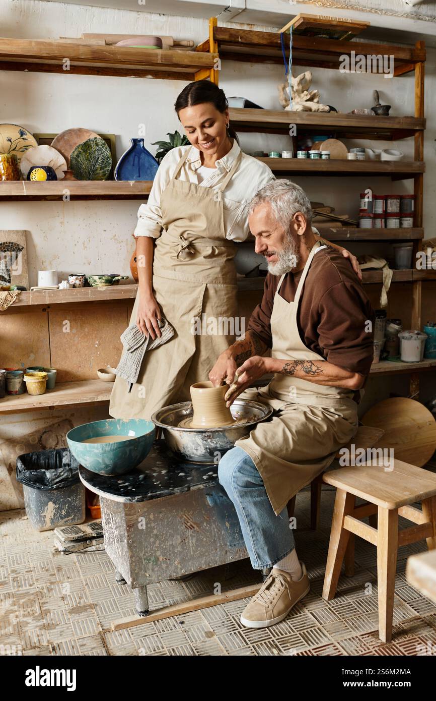 Mature couple enjoys shaping clay in a pottery class, sharing love and ...