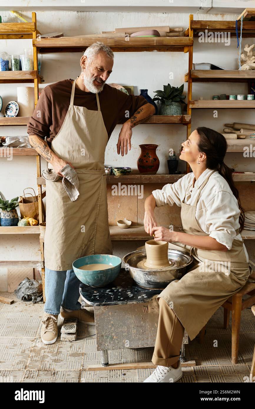 A beautiful mature couple shares laughs and creativity in a pottery ...
