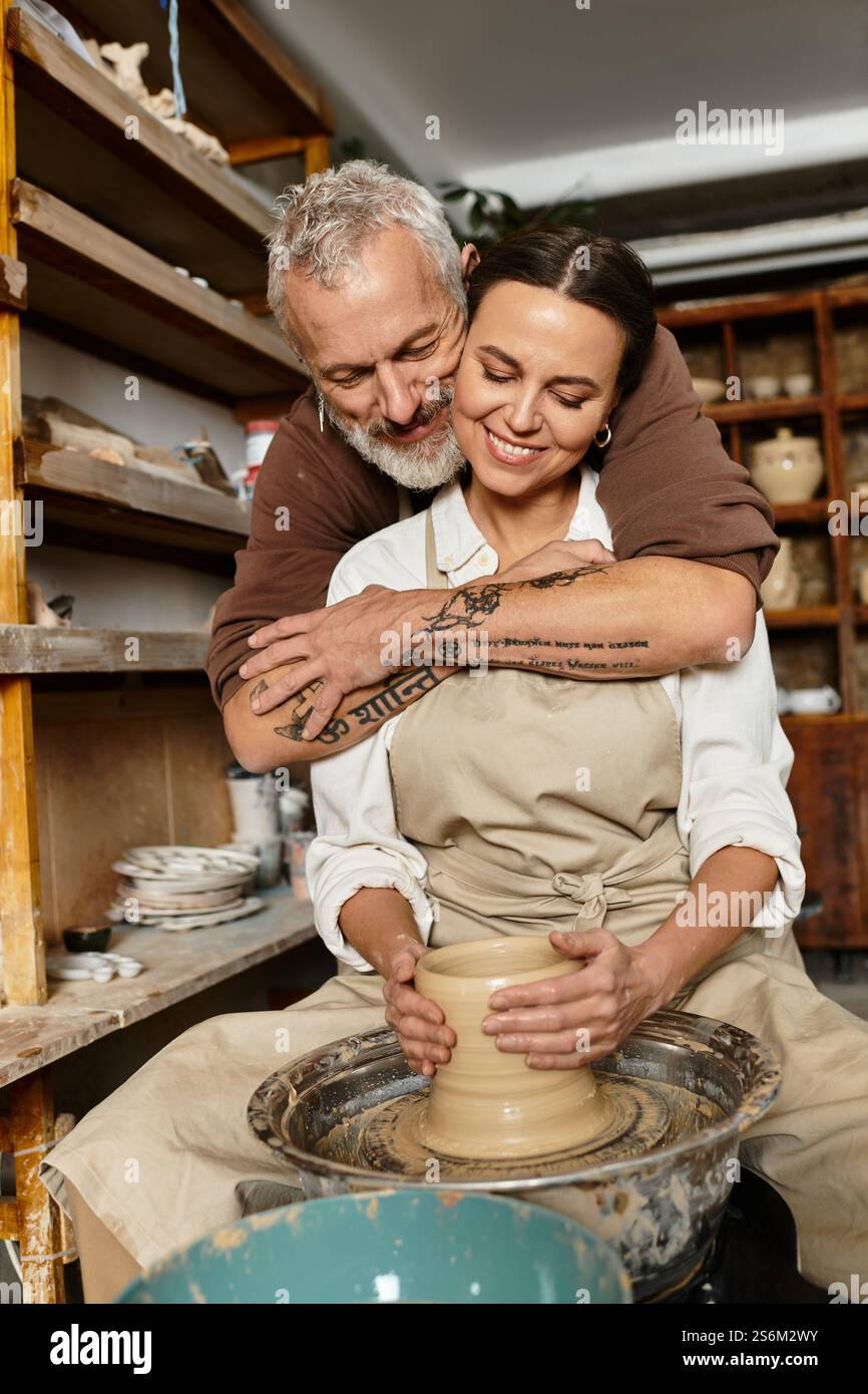 A loving couple enjoys quality time making pottery, shaping clay and ...
