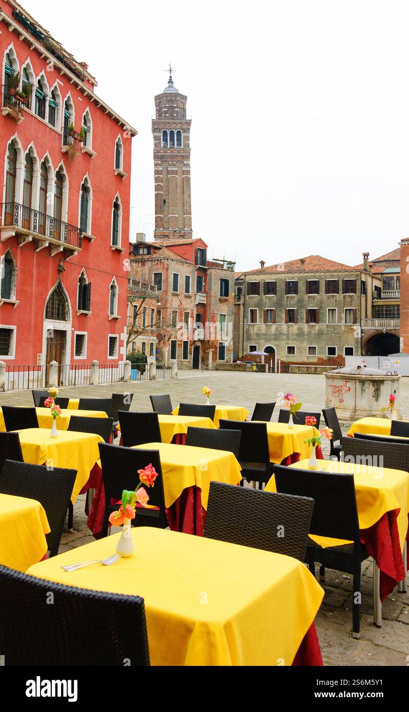 Empty romantic cafe terrace at square in Venice, Italy. Flowers on ...