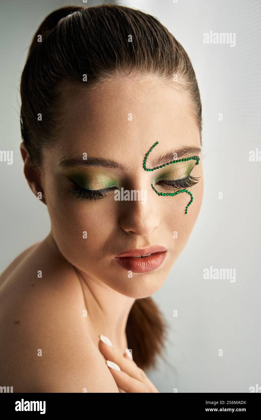 A beautiful young woman poses with eye-catching snake makeup in a ...