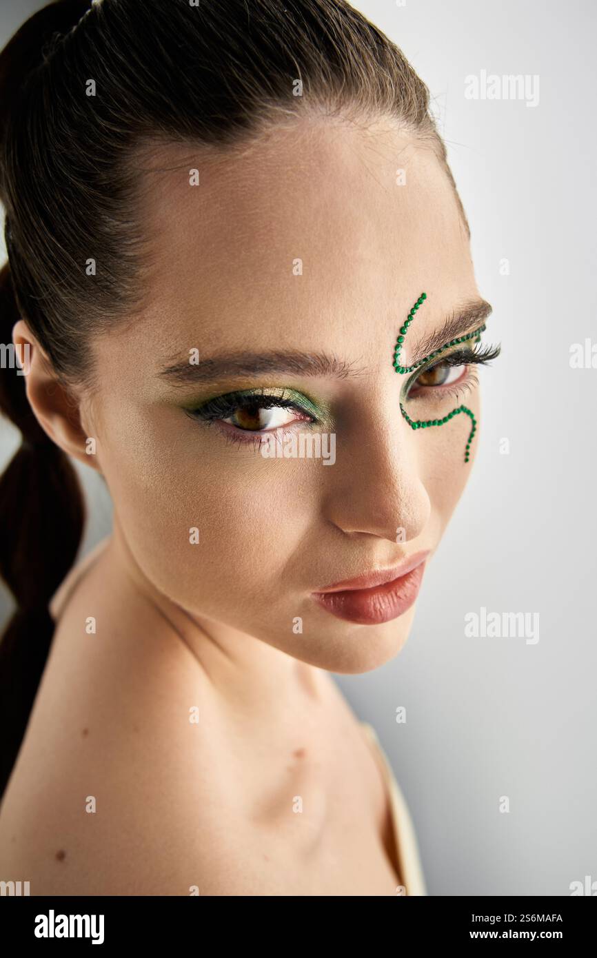 A striking young woman displays elegant snake-inspired makeup in a ...