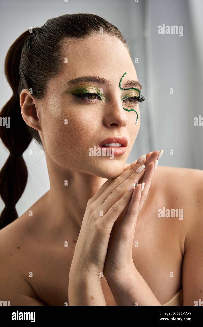 A beautiful young woman poses gracefully in a studio, featuring ...