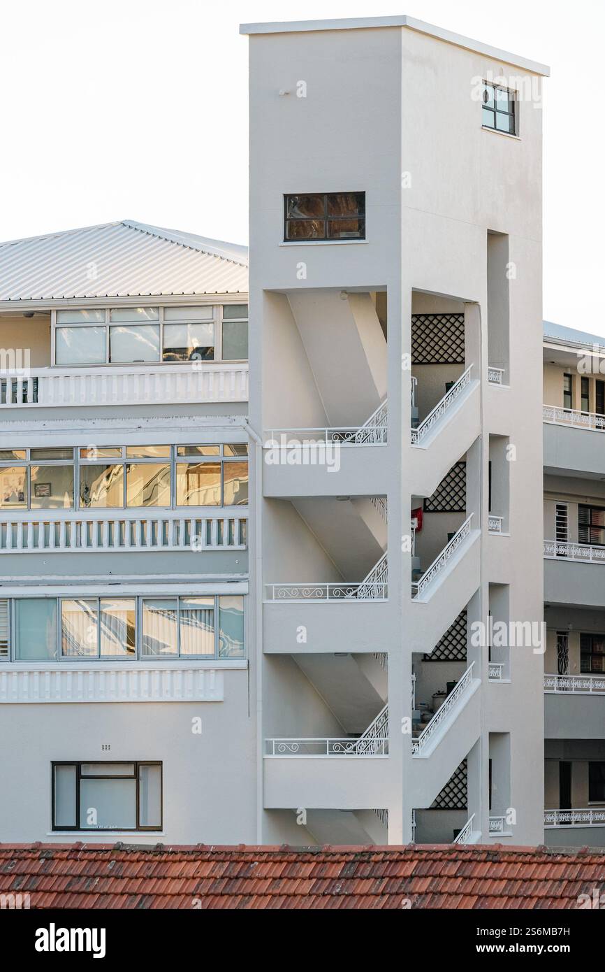 multi-story building modern architectural style light-colored facade, rectangular windows ...