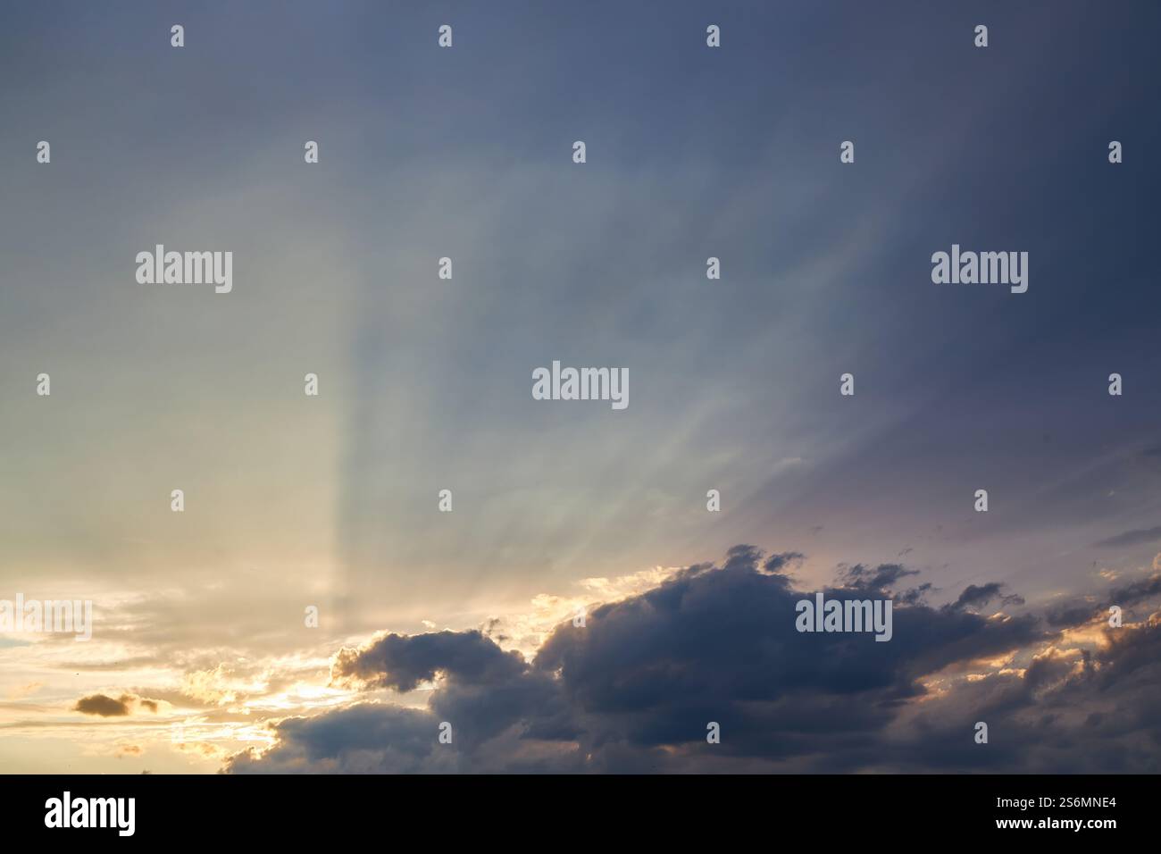 Dramatic sky with sun rays breaking through clouds during dusk, casting ...