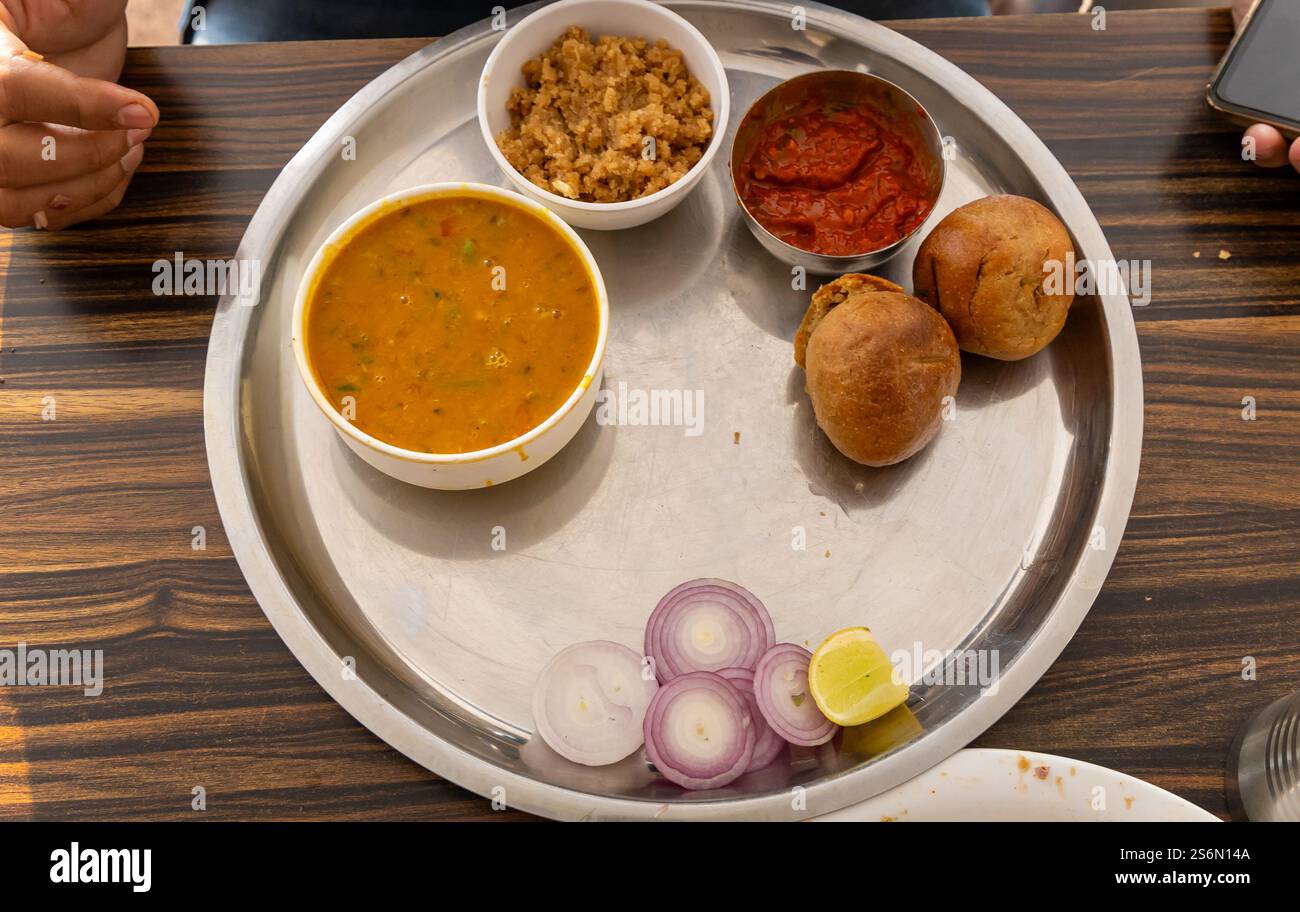 authentic indian traditional food dal bati churma served in steel plate ...