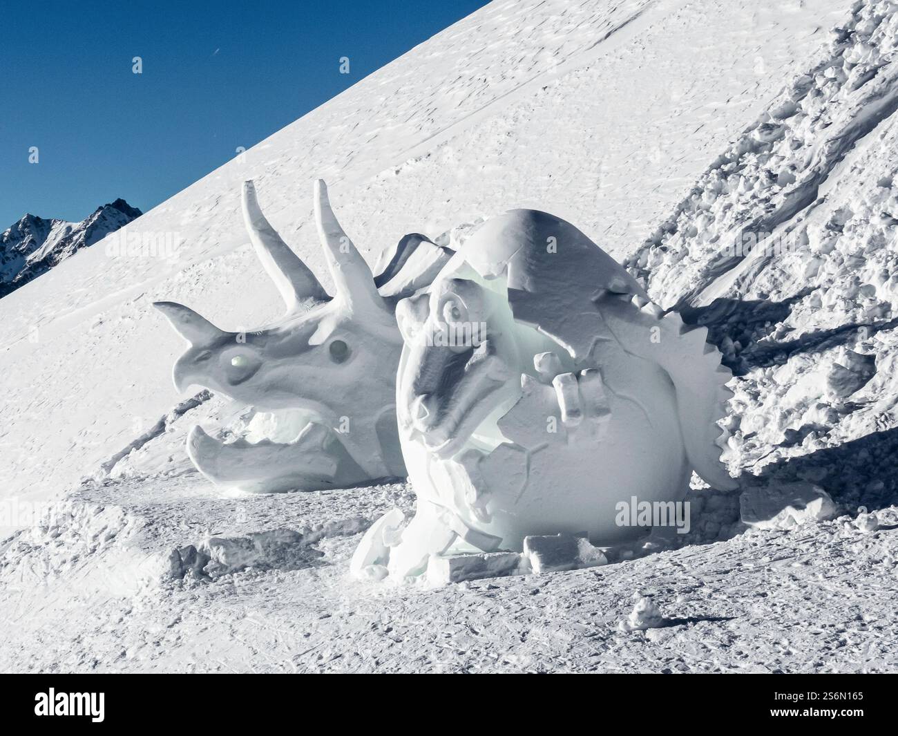A dinosaur on a ski slope - decorative sculpture made of snow Stock ...