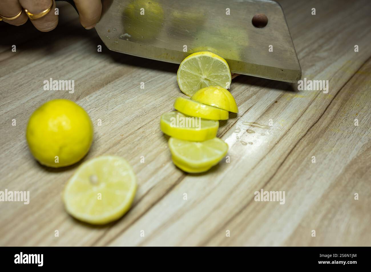 Fresh lemon slice with knife Close-Up on wood board Background studio ...