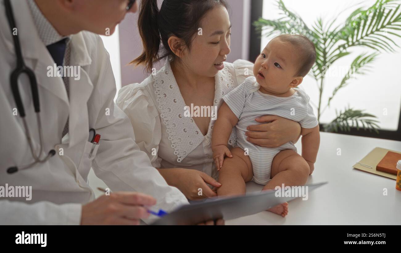 Mother holding baby boy during pediatric check-up with chinese doctor ...
