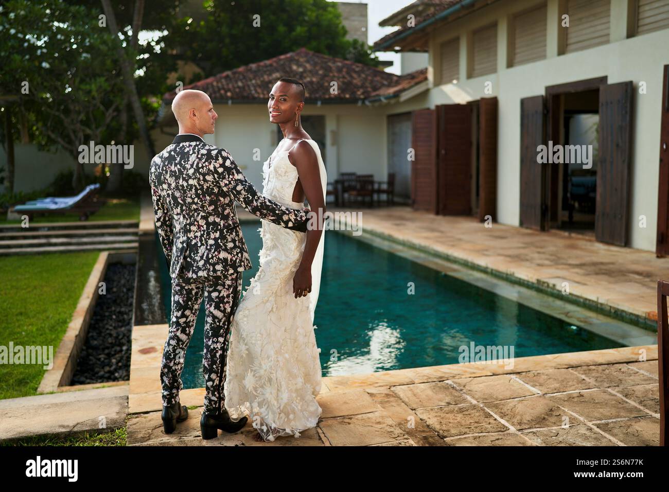 Ambiguous gender fluid person in white wedding dress beside groom in ...