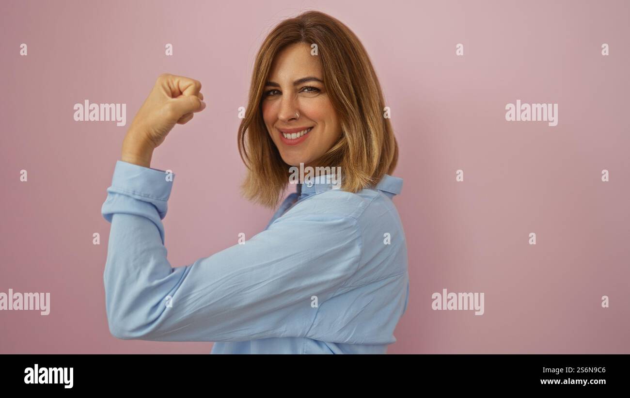 Attractive young woman smiling confidently with a strong arm pose over ...