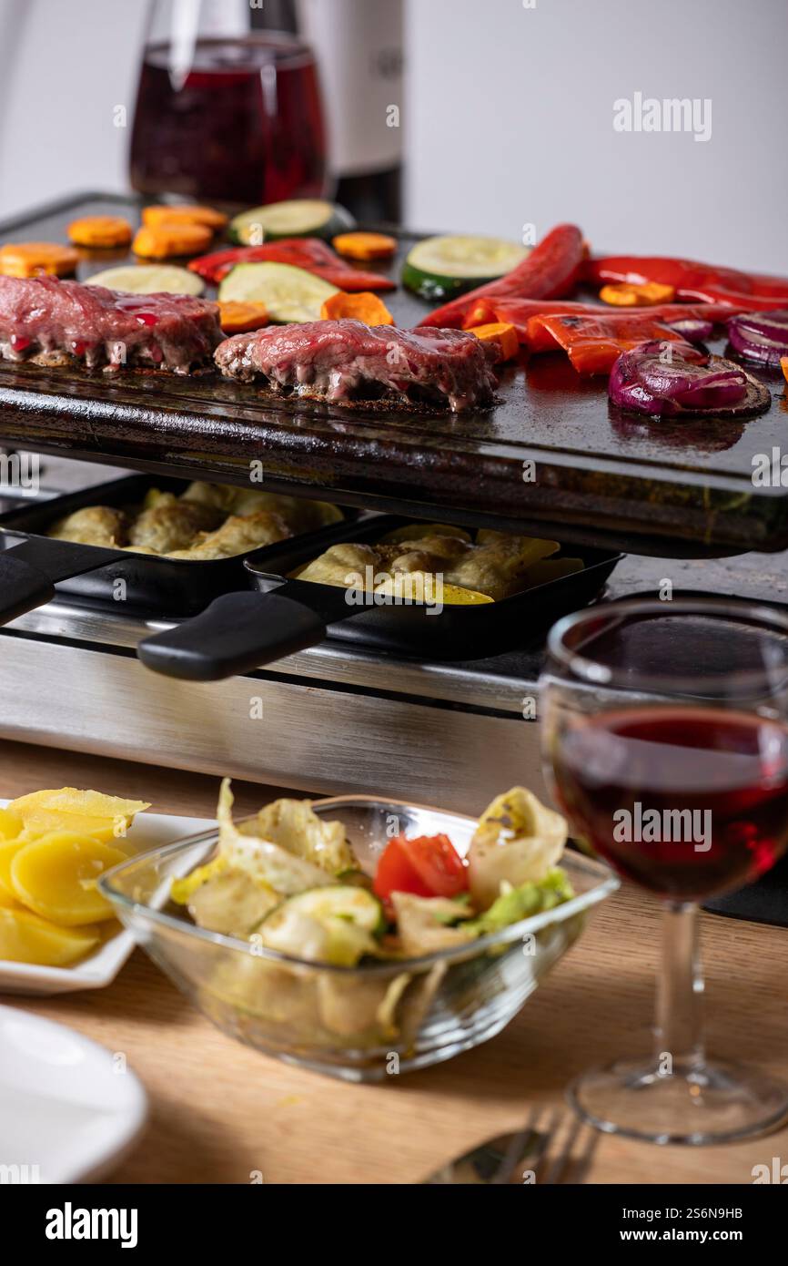 Swiss raclette with meat and vegetables Stock Photo - Alamy