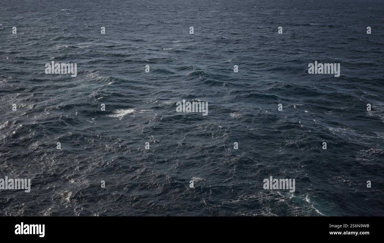 Expansive ocean waves forming textured patterns stretch across the vast ...