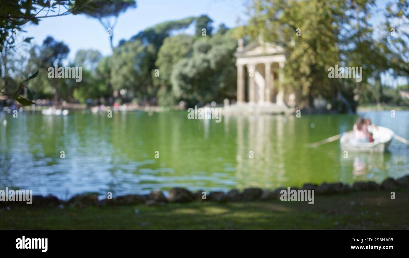 Summer tourists enjoy boating on serene lake in blurred villa borghese ...