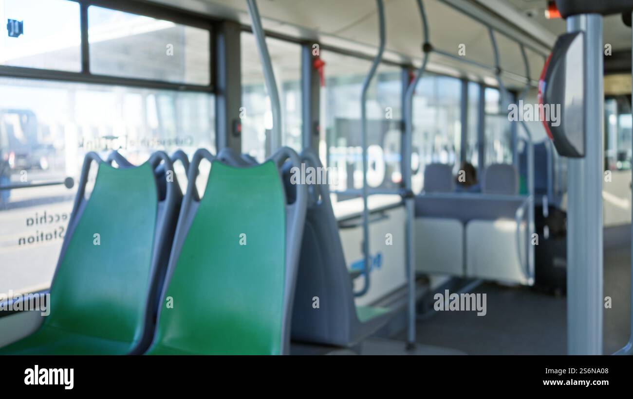 Empty bus interior featuring blurred green seats with a defocused ...
