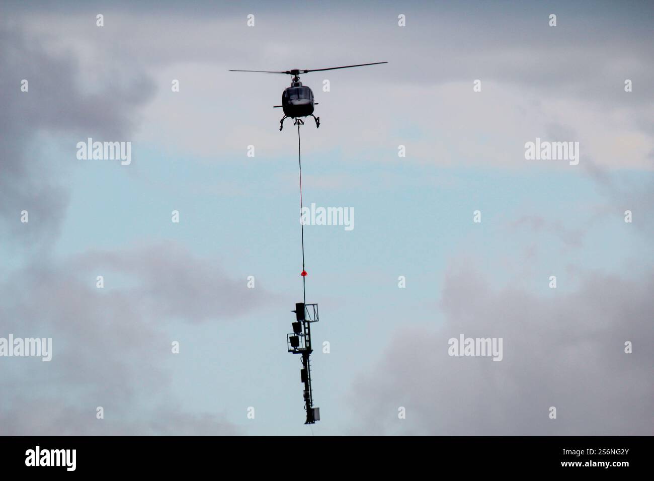 A helicopter transporting a signal mast of the railroad Stock Photo - Alamy