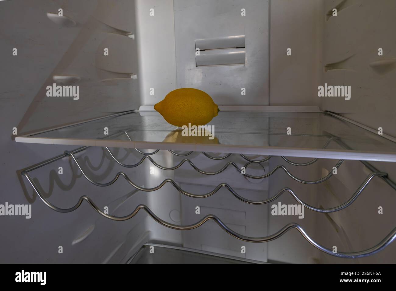 Yellow lemon in an empty fridge, empty shelves and lack of food, hunger ...