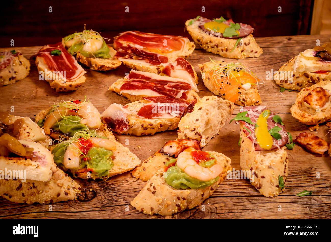 Many tapas, small baguette pieces with toppings on a table Stock Photo ...