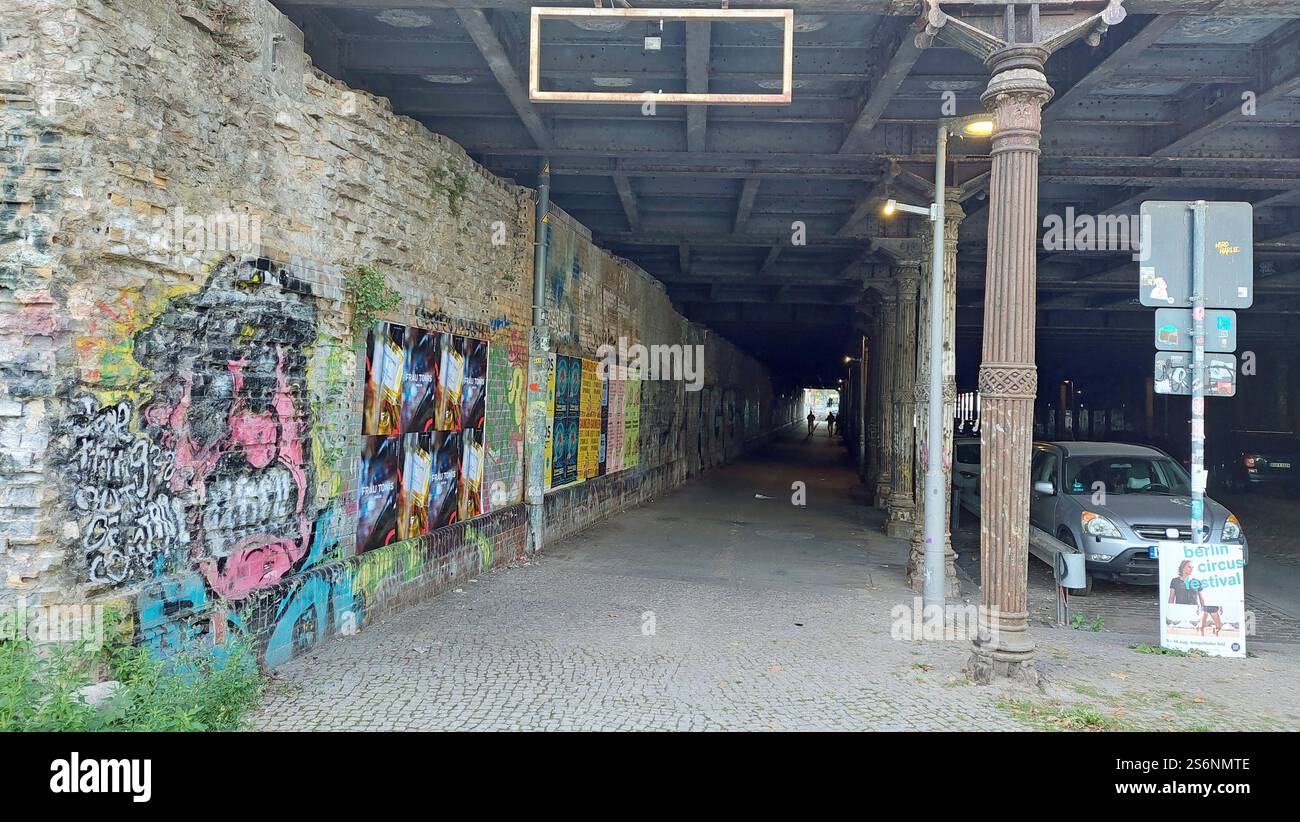 Under an old bridge with cast-iron columns, graffiti + posters Stock ...
