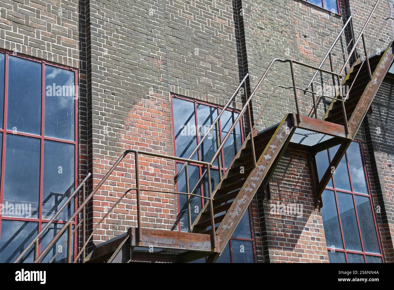 Rusty steel staircase outside brick factory building Stock Photo - Alamy