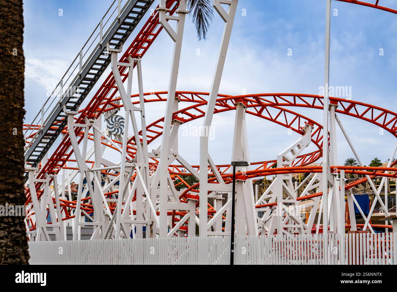 A roller coaster with orange and white tracks. The roller coaster is in ...