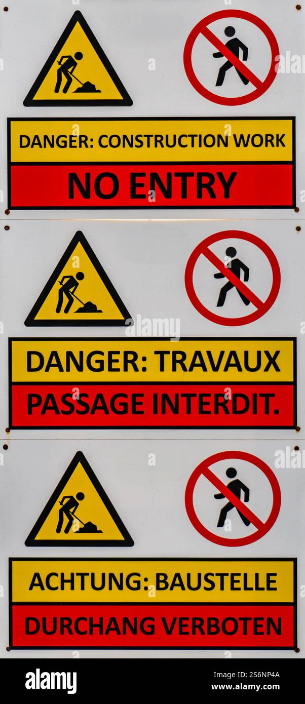 Four signs with a yellow and red triangle on them, one of which says ...