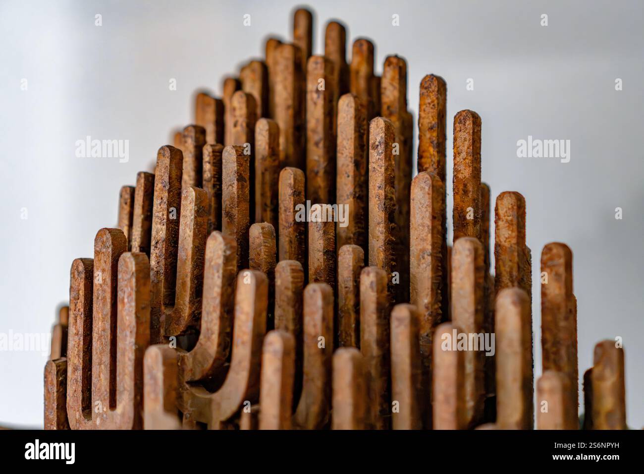 A pile of rusty metal sticks with a triangular shape. The sticks are ...