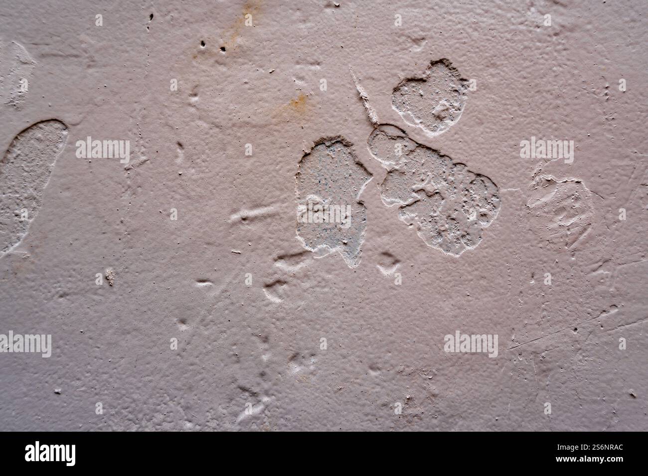 A wall with a lot of cracks and marks on it. The wall is made of ...