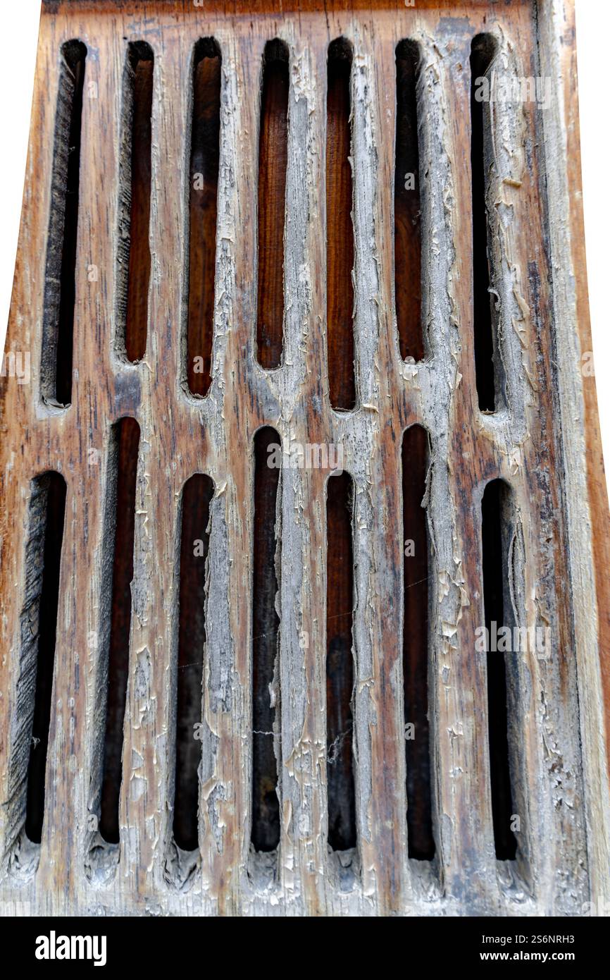 A wooden grate with many holes in it. The holes are spaced out in a ...