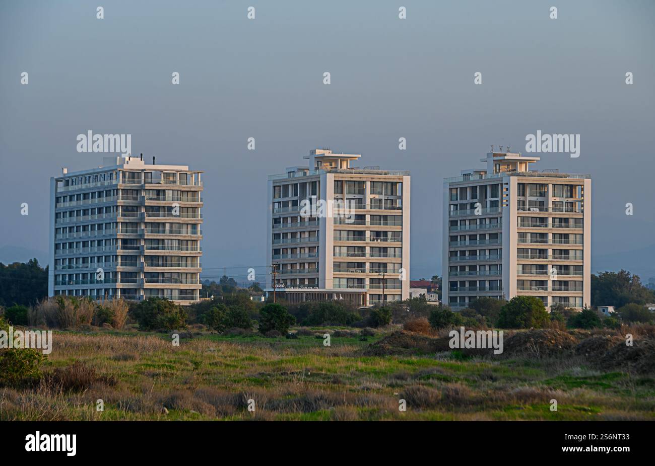 Three sleek high-rise buildings rise against a serene backdrop ...