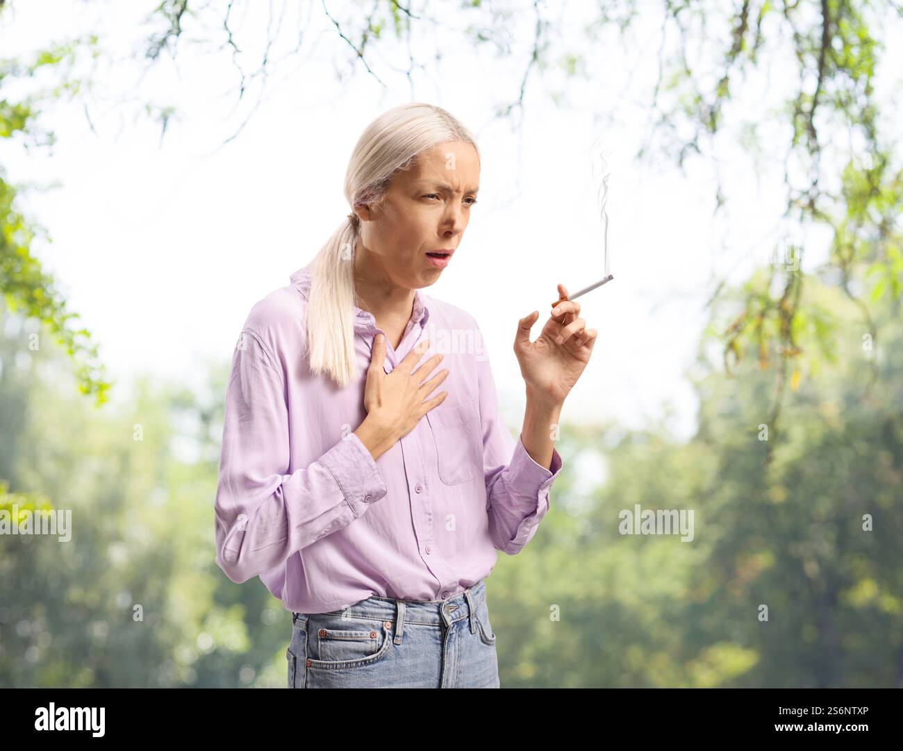 Woman smoking and coughing outdoors in nature Stock Photo - Alamy