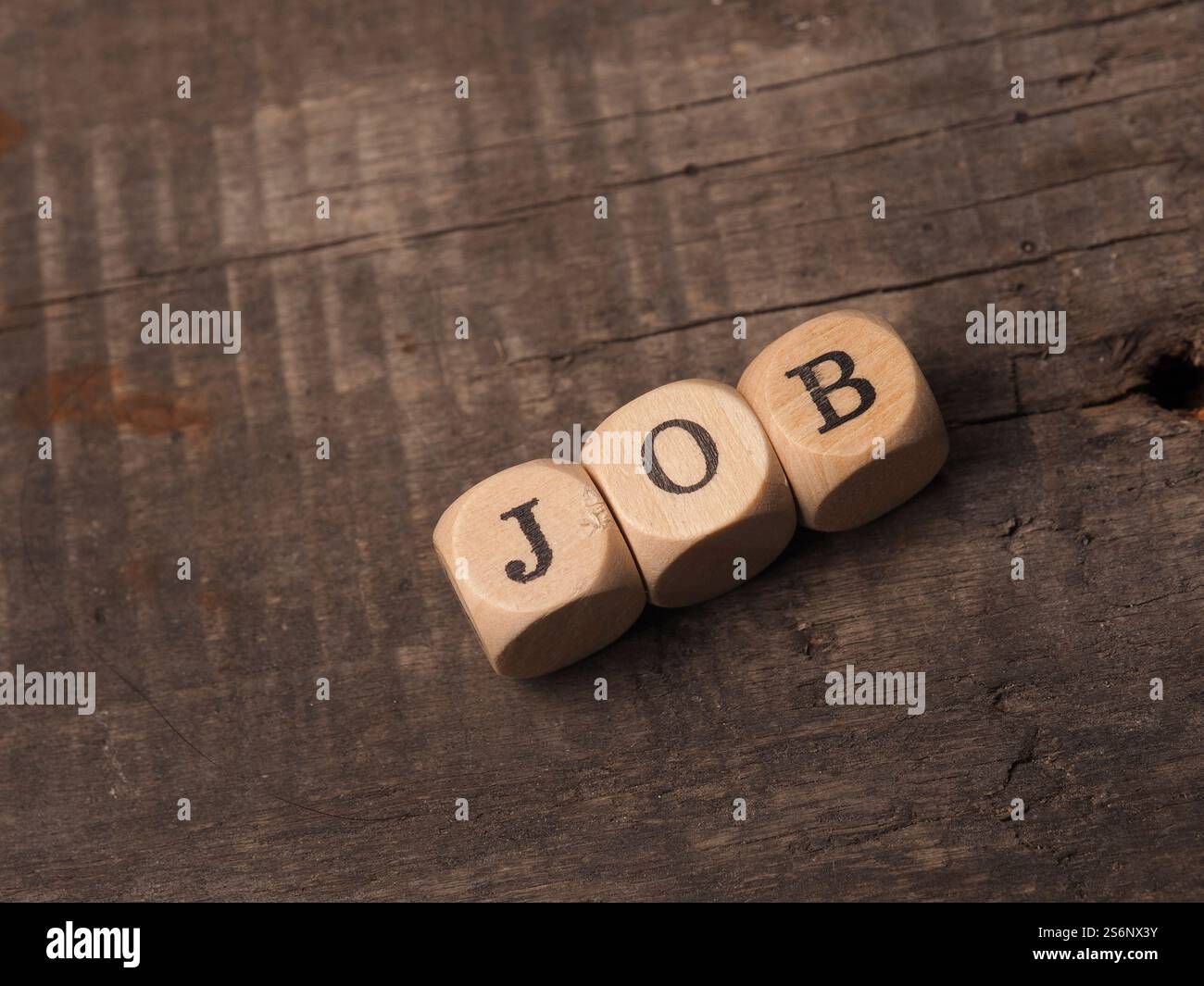 Wooden dices with the word job on a rustic wooden table with space for ...