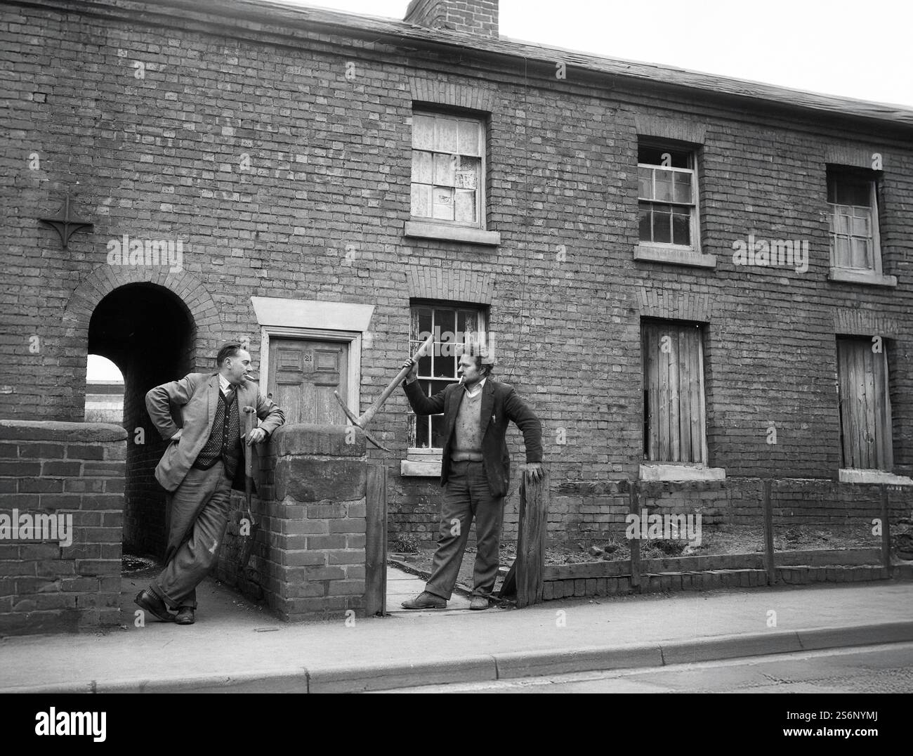 Working men neighbours talking outside terraced homes in Britain 1962 ...