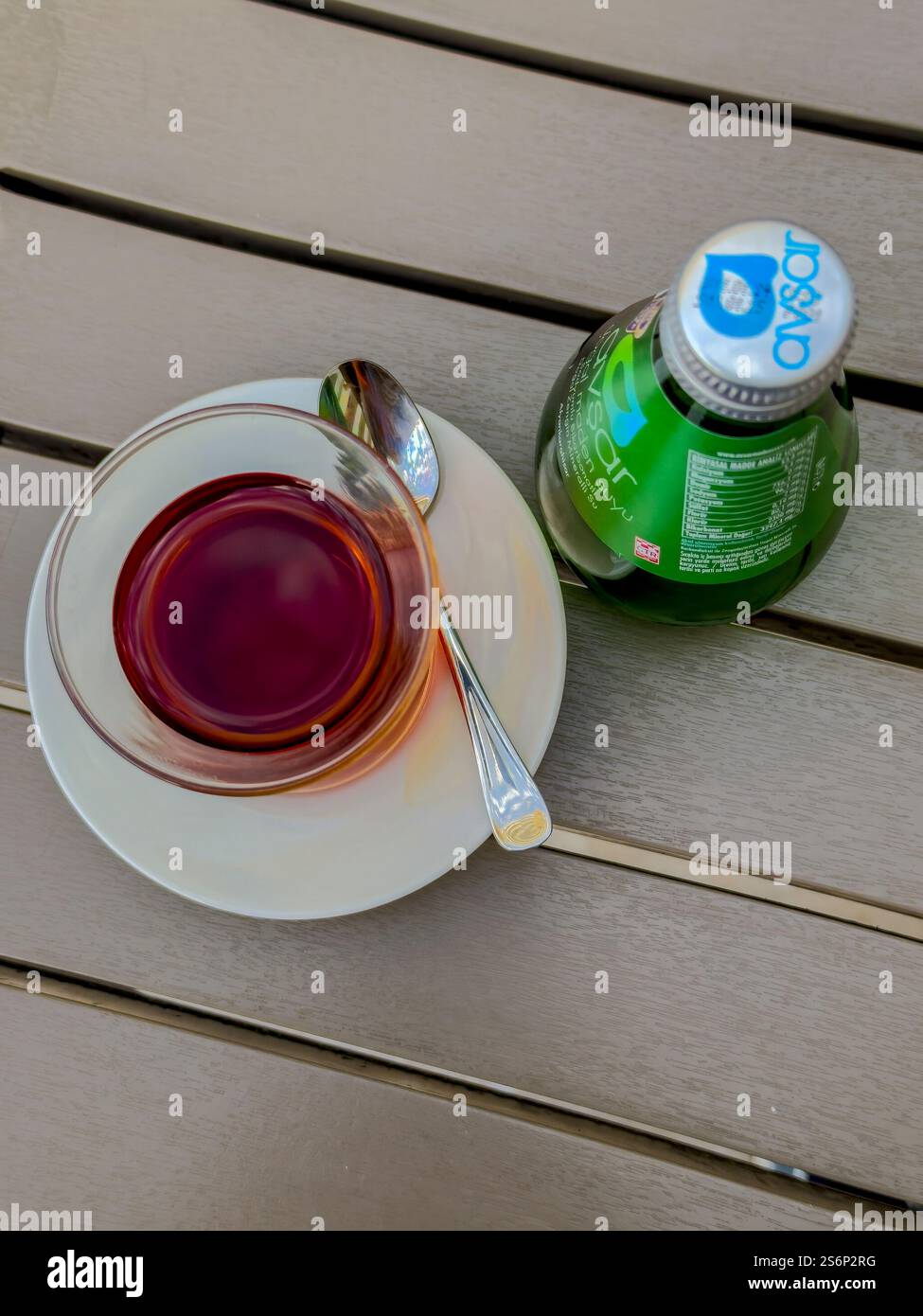 A glass of hot, aromatic Turkish tea next to refreshing mineral water ...