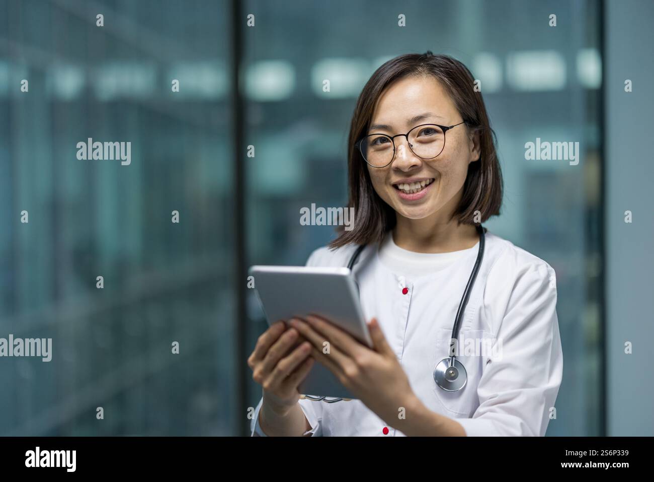 Portrait of a young Asian female doctor inside the office at her ...