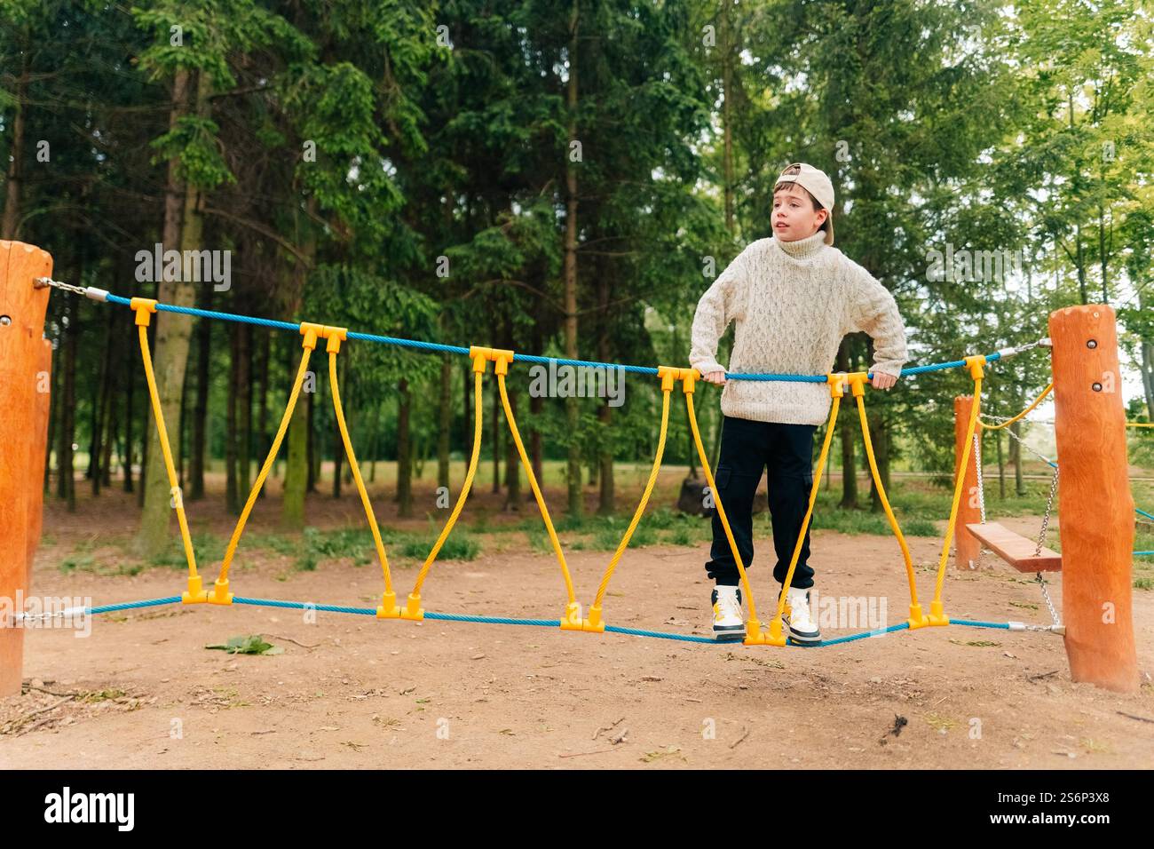 Teen boy playing in a rope town on the playground, obstacles Stock ...