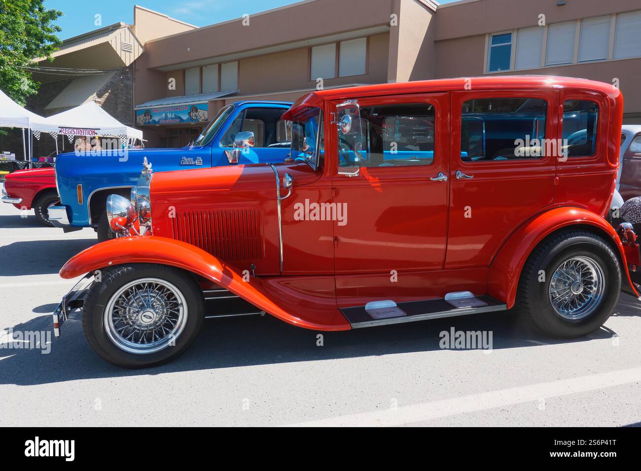 A bright orange 1932 Ford 4 door sedan on display at a car show in ...